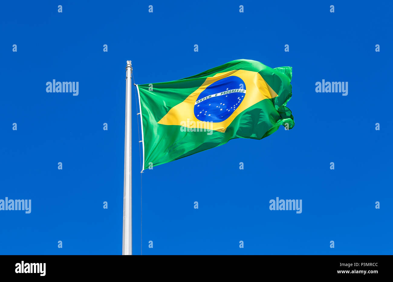 Flag of Brazil flying in the wind against the blue sky Stock Photo - Alamy