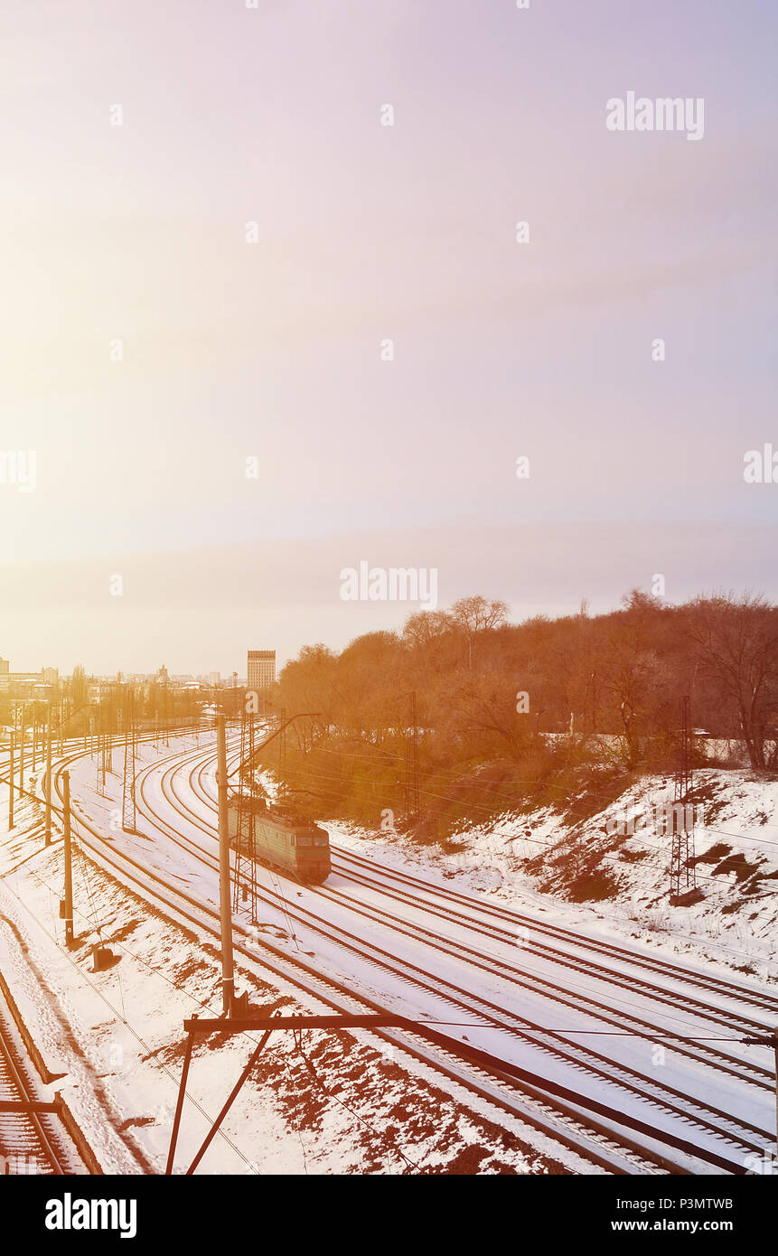 Winter landscape with a railway train on a railway surrounded by a city ...