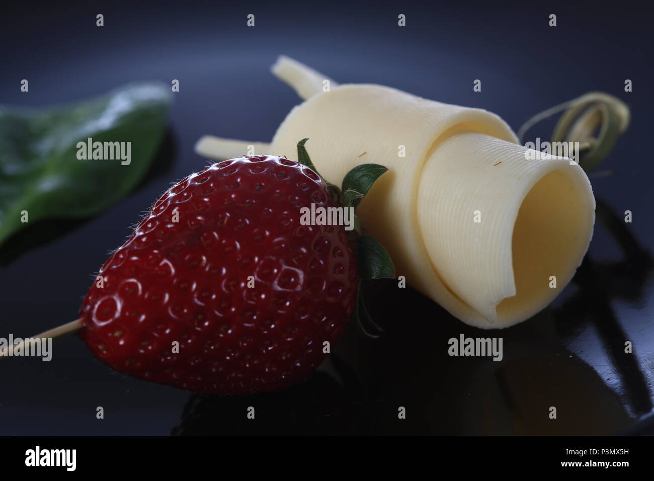 A slice of yellow cheese with a strawberry Stock Photo - Alamy