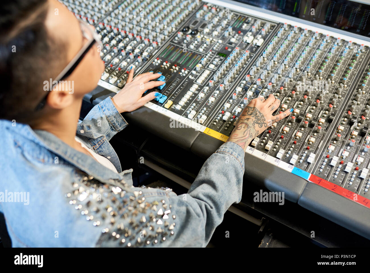 Tattooed woman working on control console Stock Photo - Alamy
