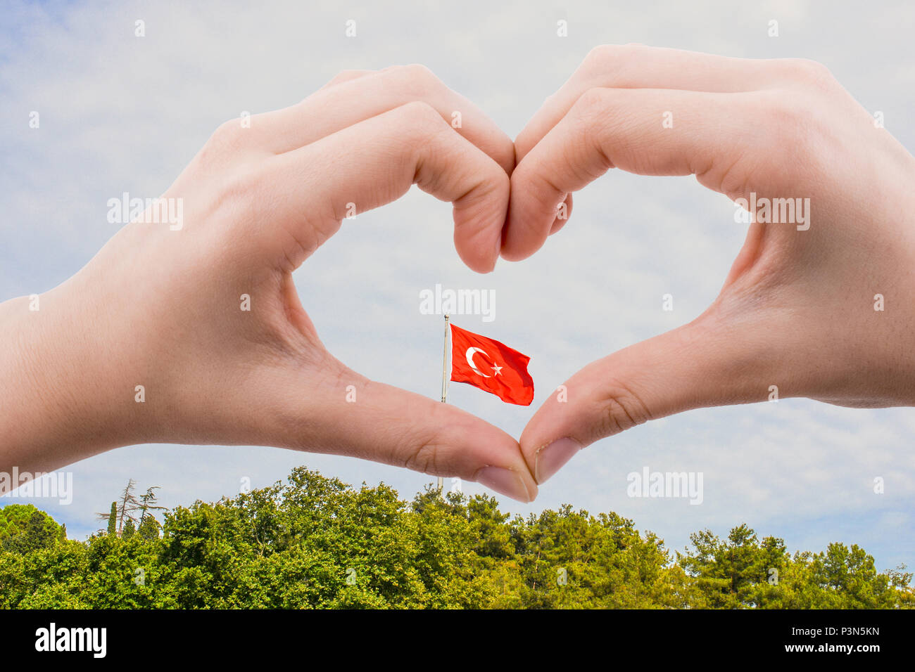 Turkish flag seen behind a heart shaped hand Stock Photo - Alamy
