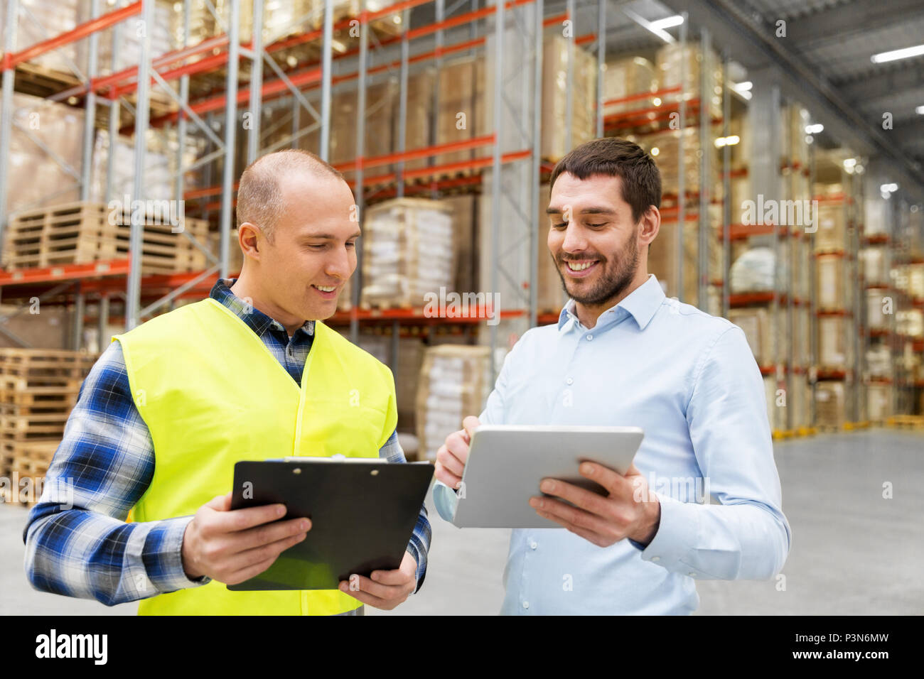 worker and businessman with tablet pc at warehouse Stock Photo - Alamy