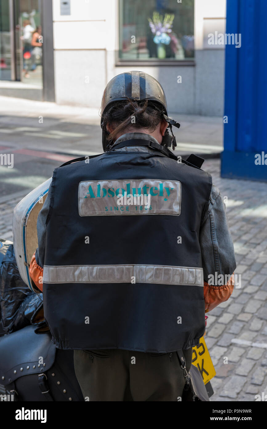 a motorcycle courier in the city of London wearing an old fashioned or ...