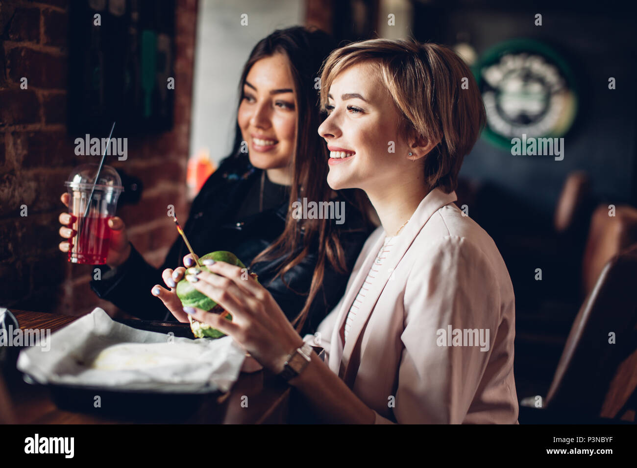 Two girl friends having supper with green sandwich in burger bar Stock ...