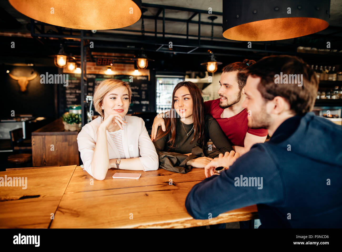 Friends Meeting in bar with loft interior Stock Photo - Alamy