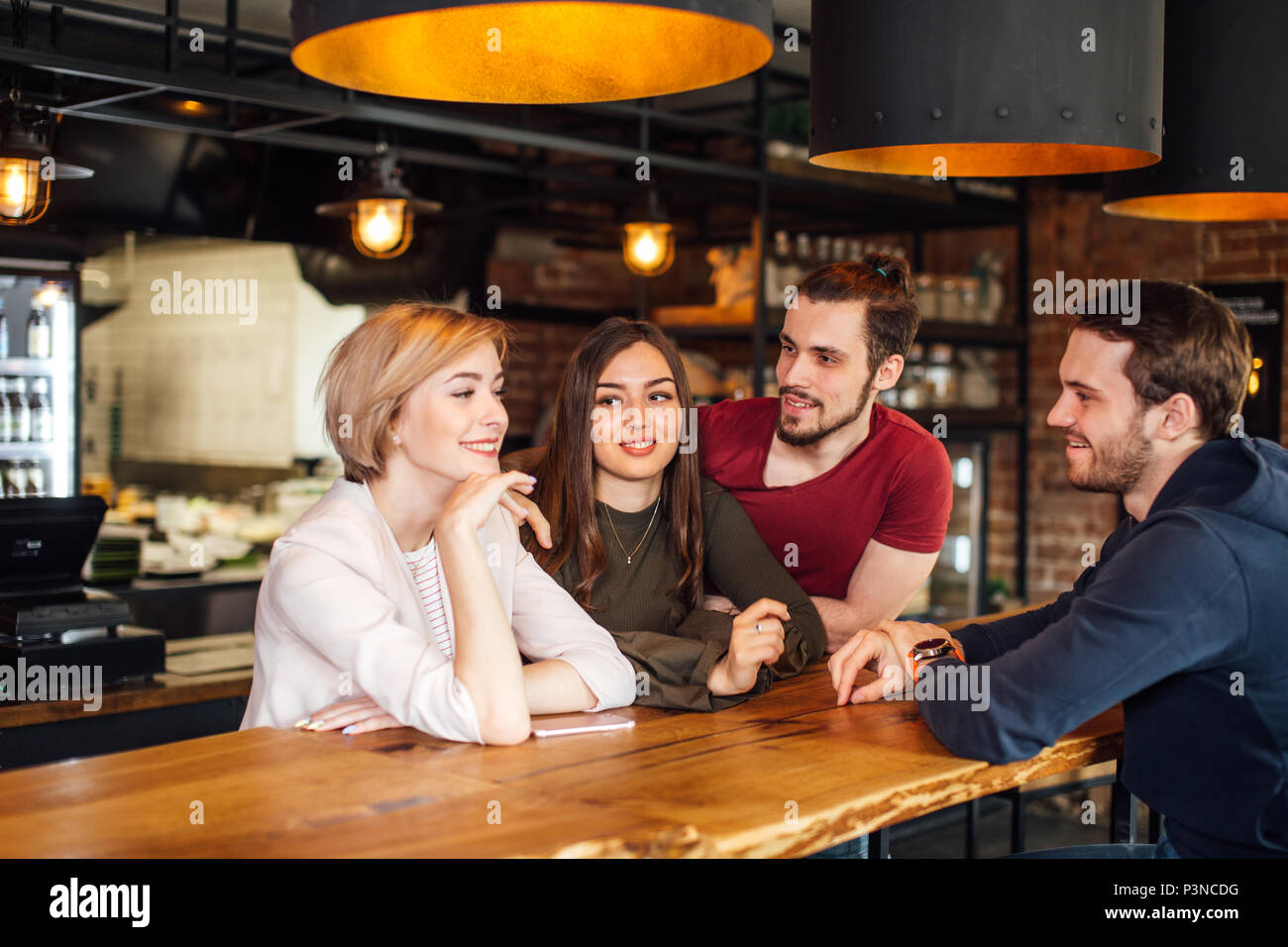 Friends Meeting in bar with loft interior Stock Photo - Alamy