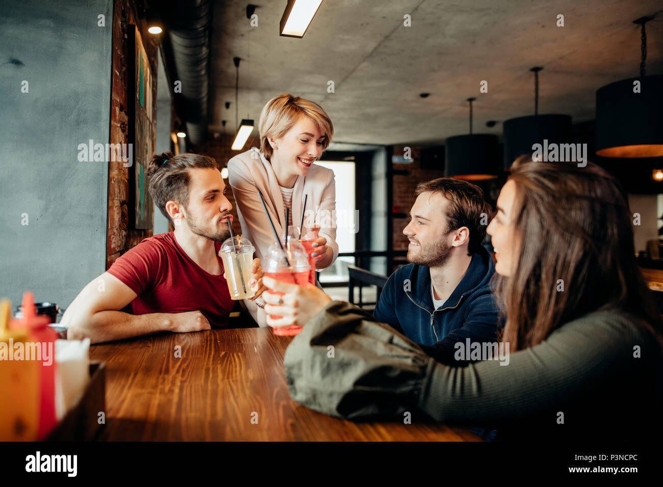 Happy friends drinking beverages having fun while spending time ...