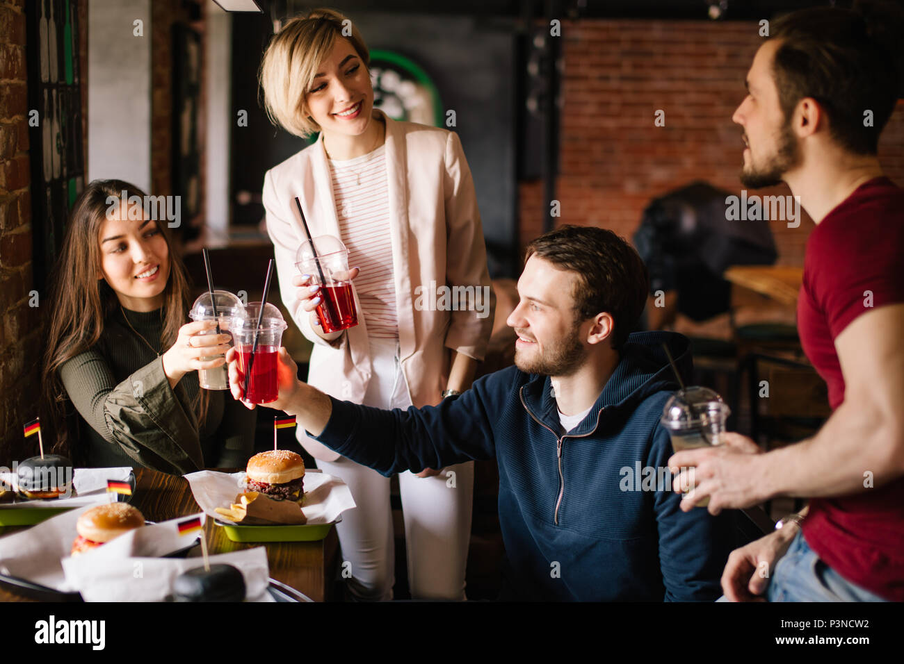 Friends clinking glasses together in a cheer at bar Stock Photo - Alamy
