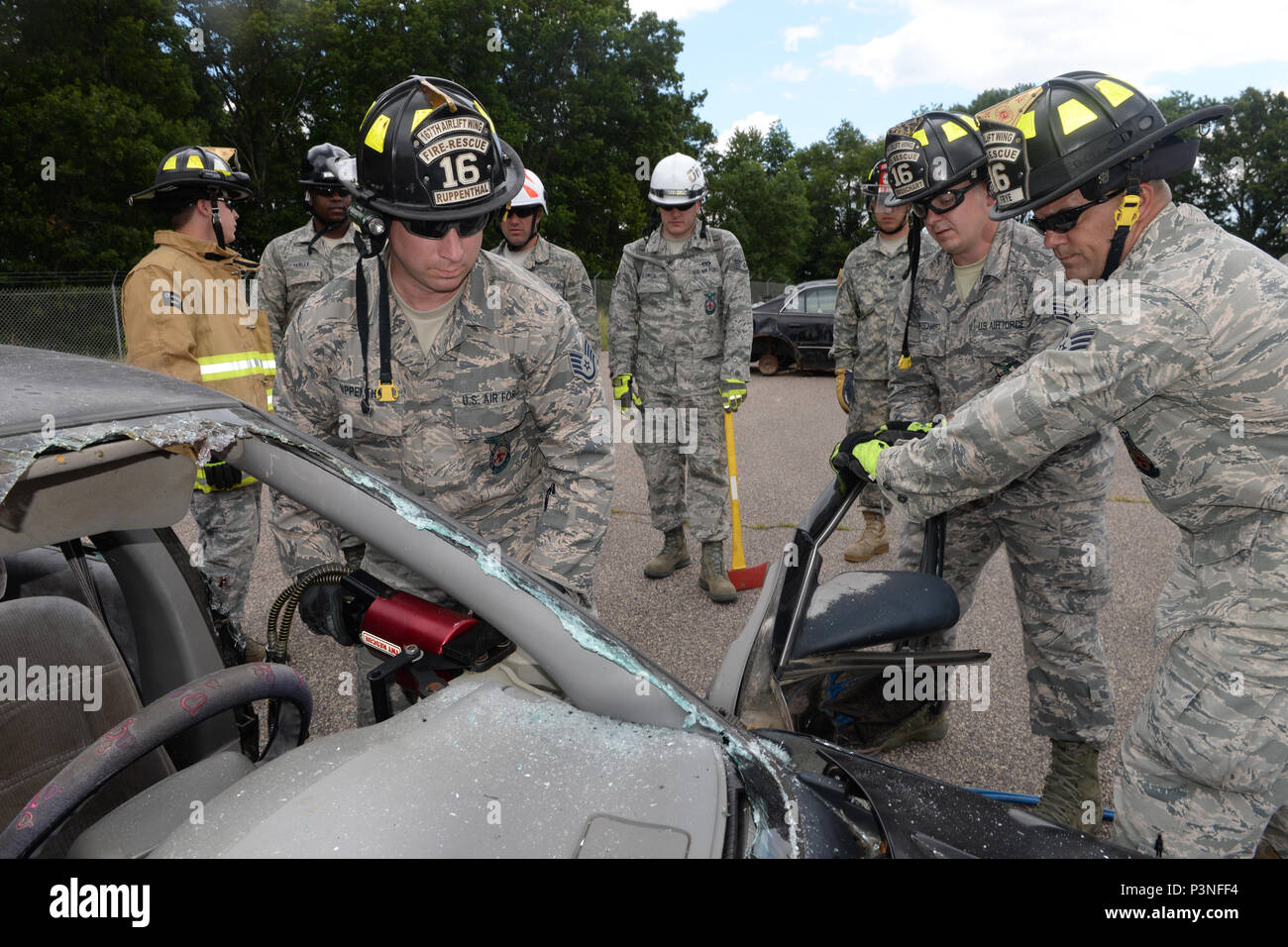 Staff Sgt. Michael Frye holds a car door as Staff Sgt. Joseph ...