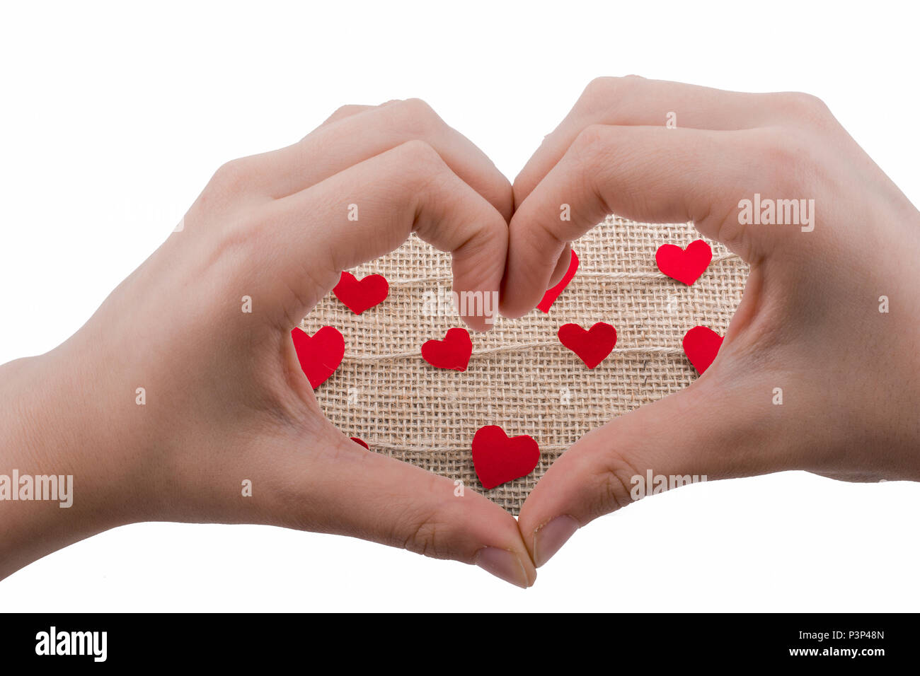 Paper heart shapes behind a heart shaped hand Stock Photo - Alamy