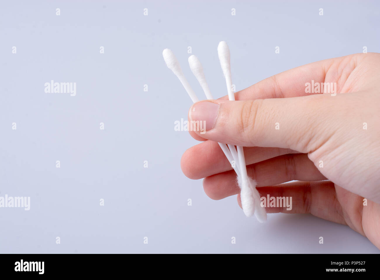 A few ear sticks in hand isolated on white background Stock Photo - Alamy
