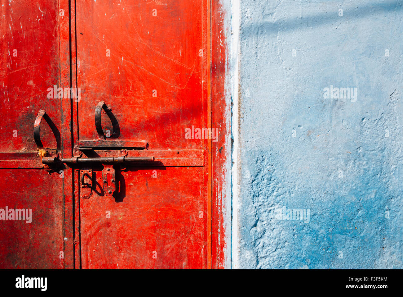 Old rusty red metal door and blue wall Stock Photo - Alamy