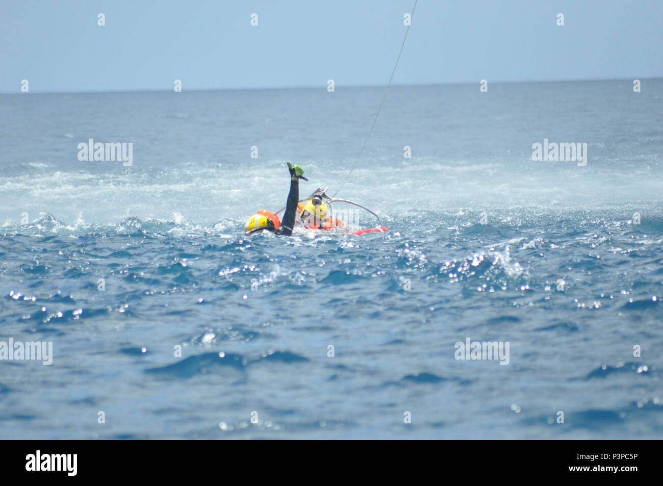 The U.S. Coast Guard diver signals the chopper to lift a member of the ...