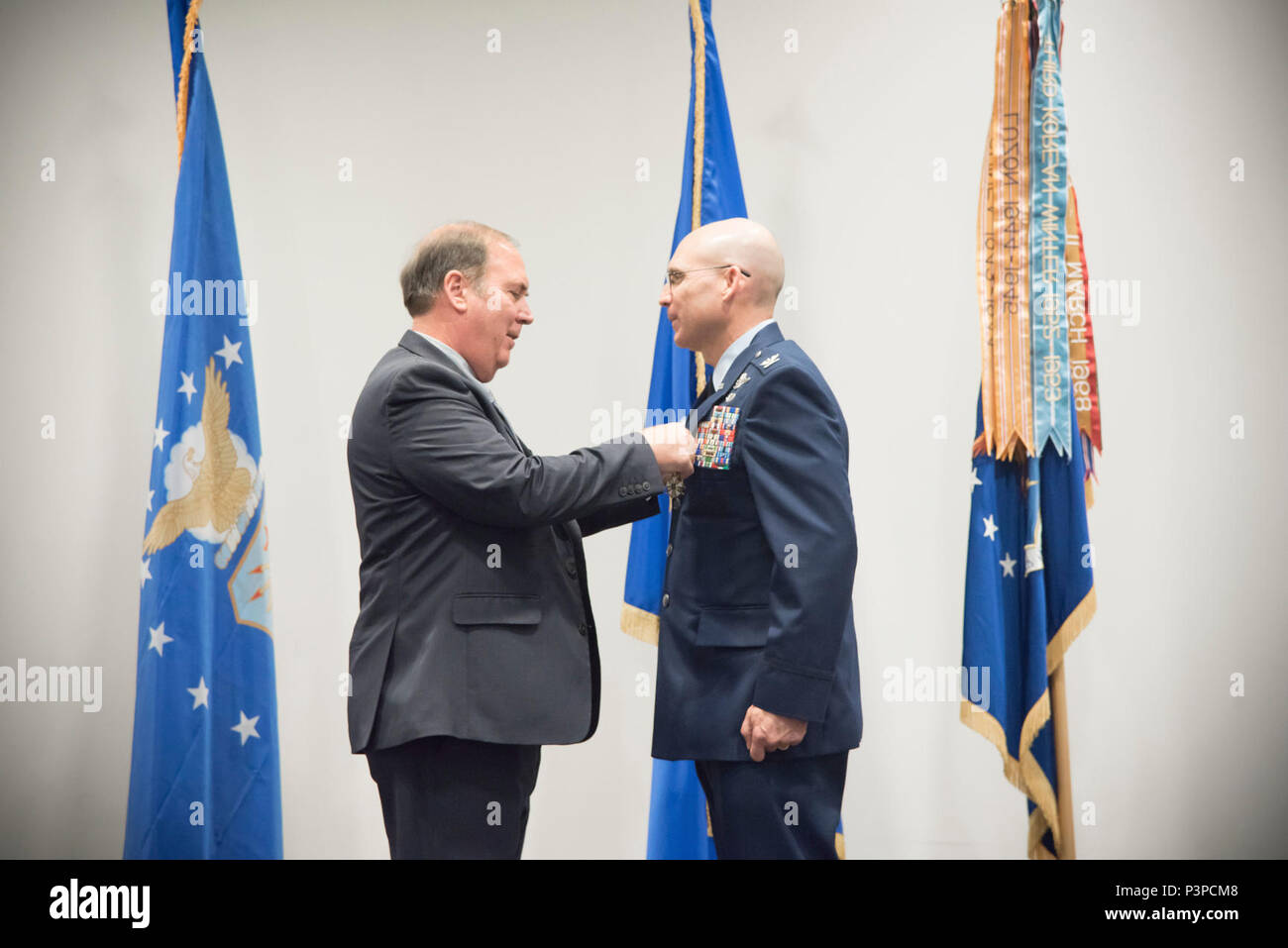 Col. Tommy Hull (ret.) pins a Legion of Merit medal on the lapel of Col ...