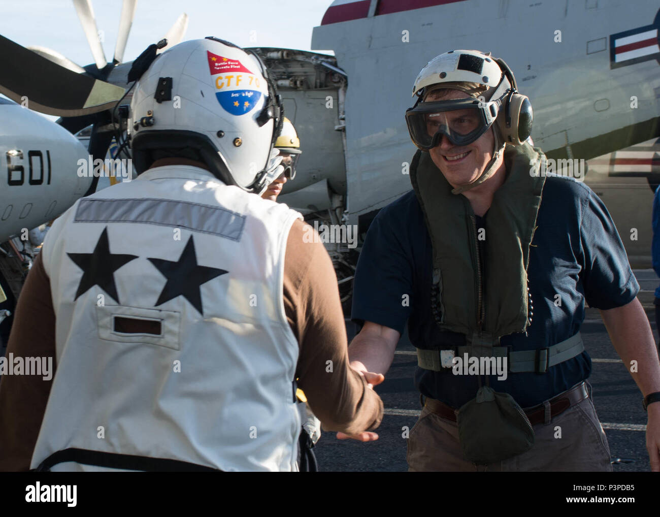 Rear Adm. John D. Alexander, commander of Task Force 70, shakes hands ...