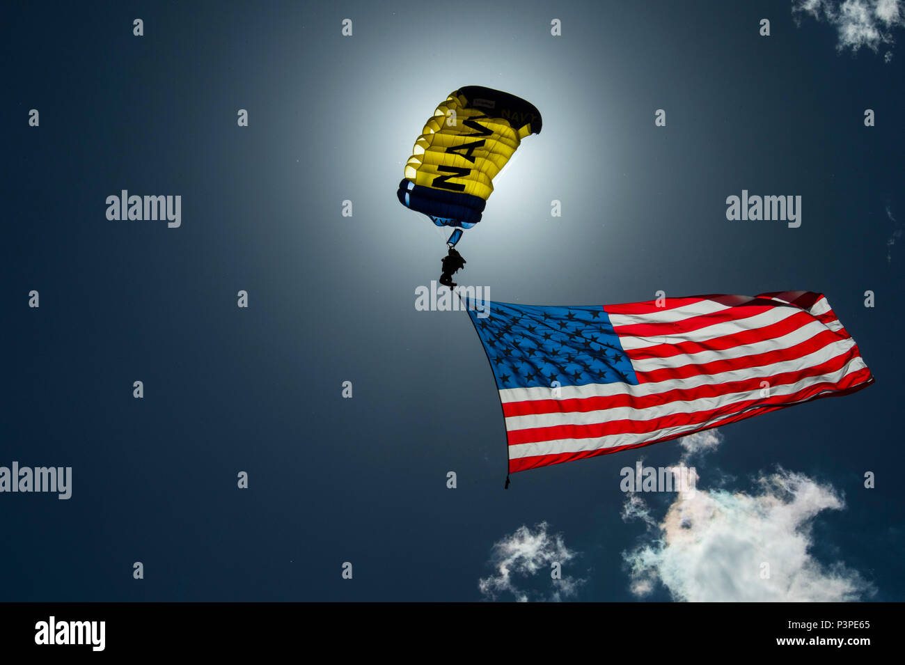 A member of the Navy Leap Frogs bearing the American flag, descends ...