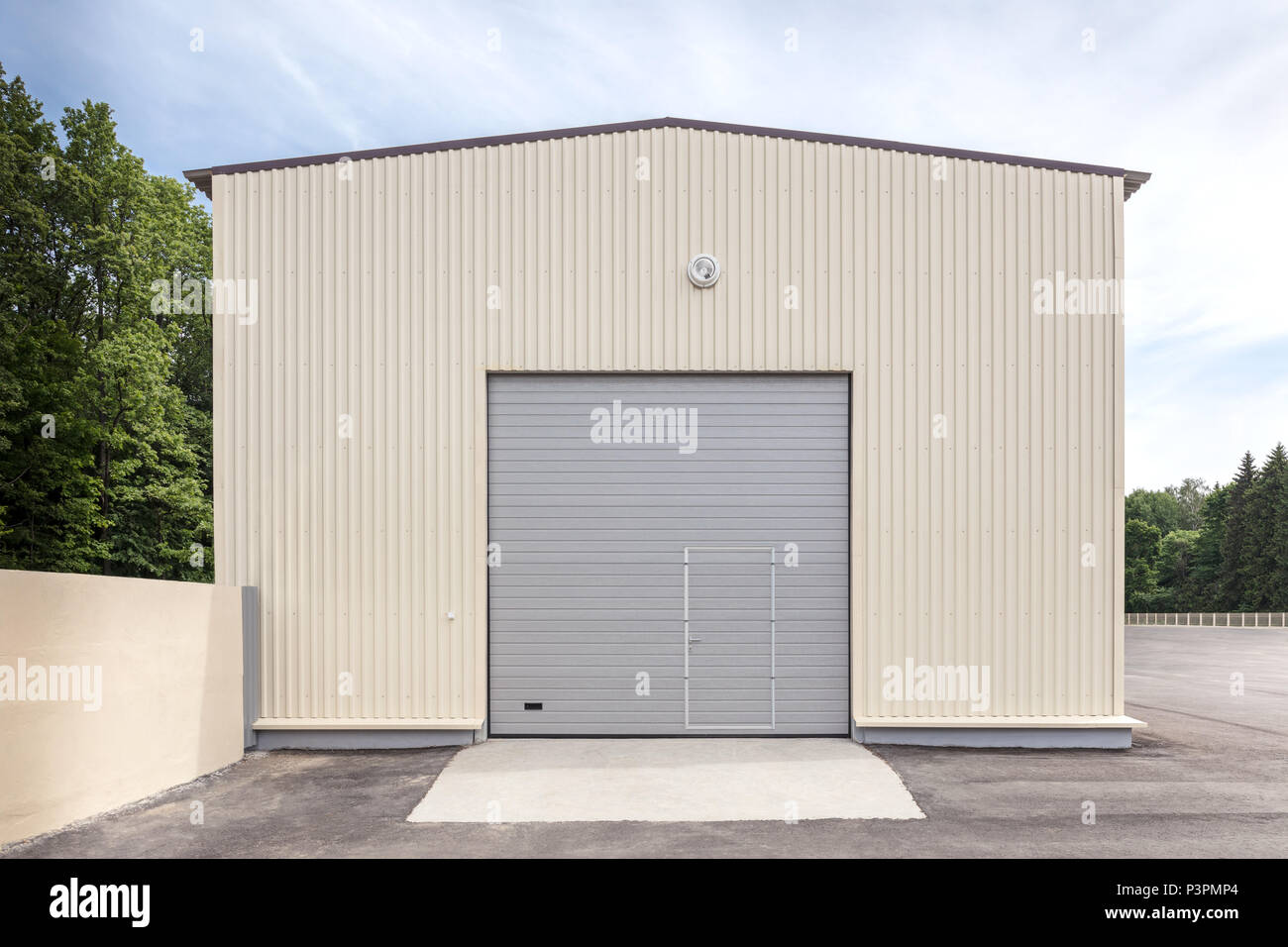 facade of industrial storehouse with closed gray metal gate and door ...