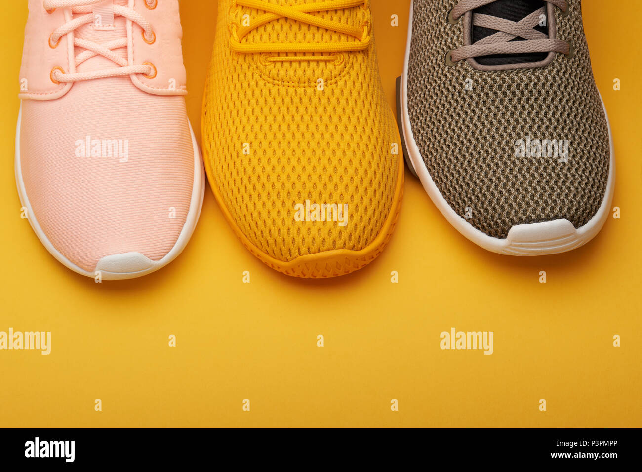 Flat lay of colorful running shoes on yellow background Stock Photo - Alamy