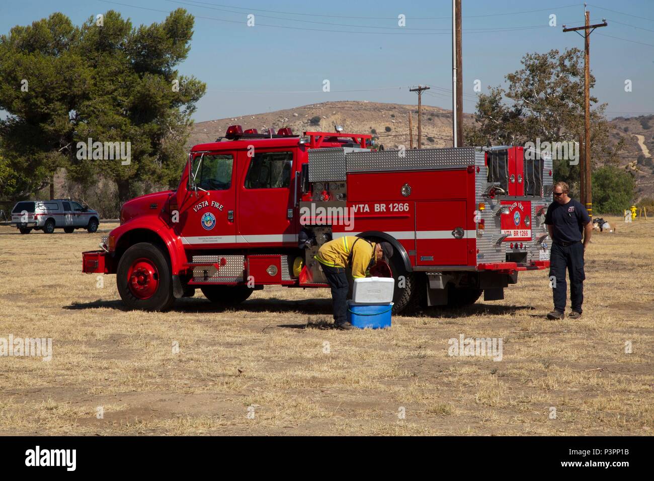 Civilians with Camp Pendleton Fire Department fill up a cooler with ...