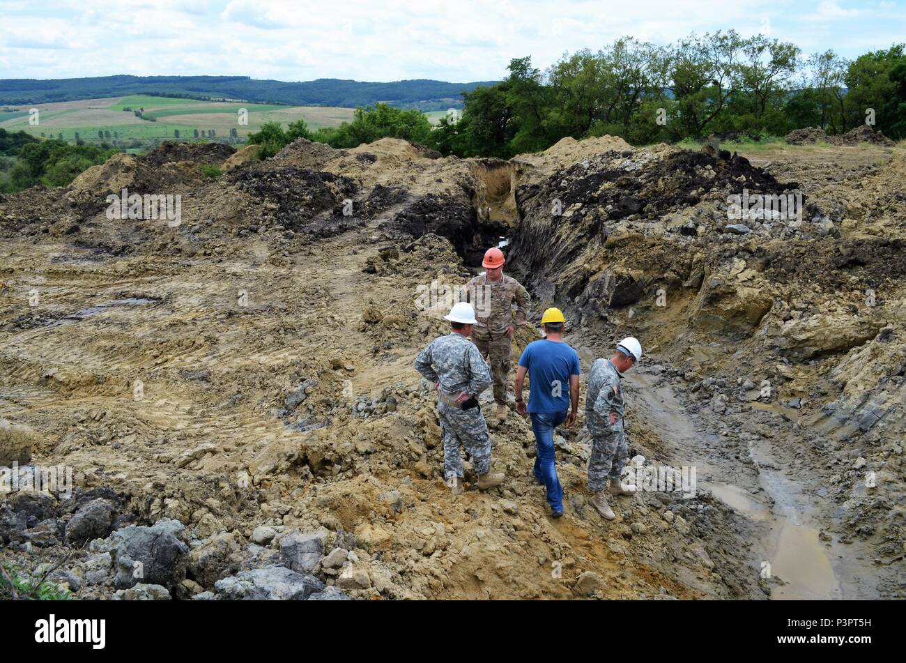 United States Army and Romanian Engineers examine the progress of the ...