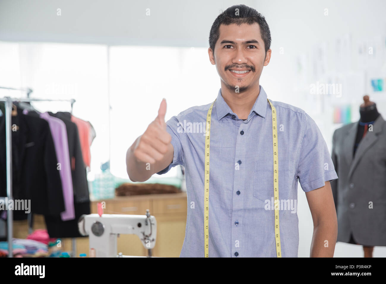 fashion designer showing thumb up to camera Stock Photo - Alamy