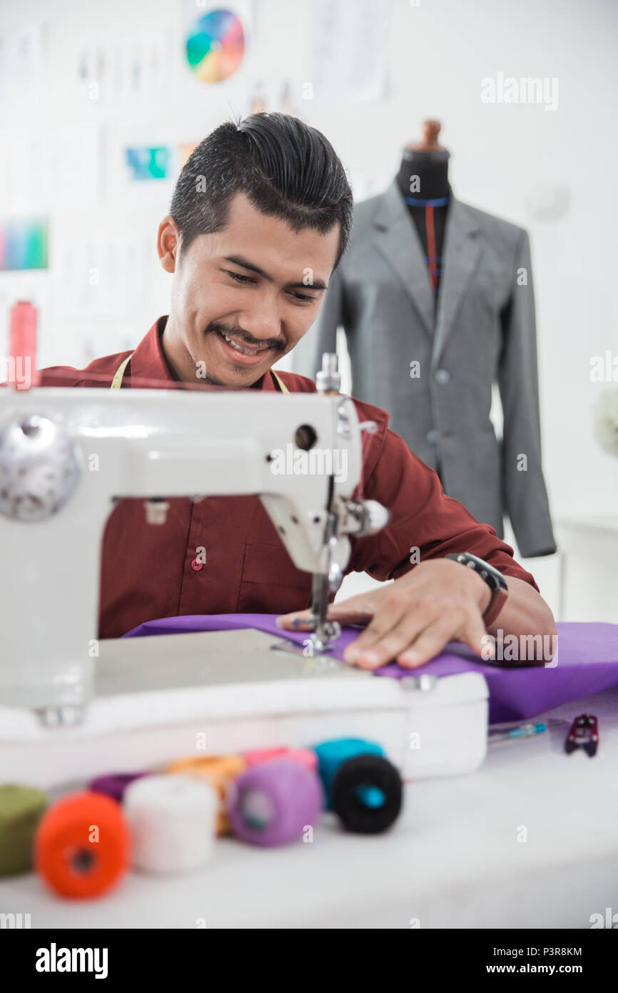 fashion designer using sewing machine Stock Photo - Alamy