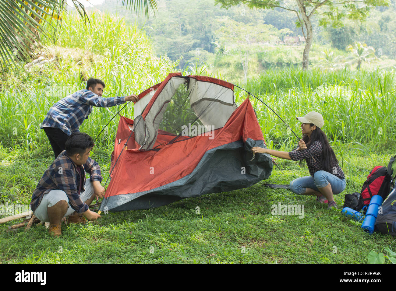 tourist help each other prepare tent Stock Photo - Alamy