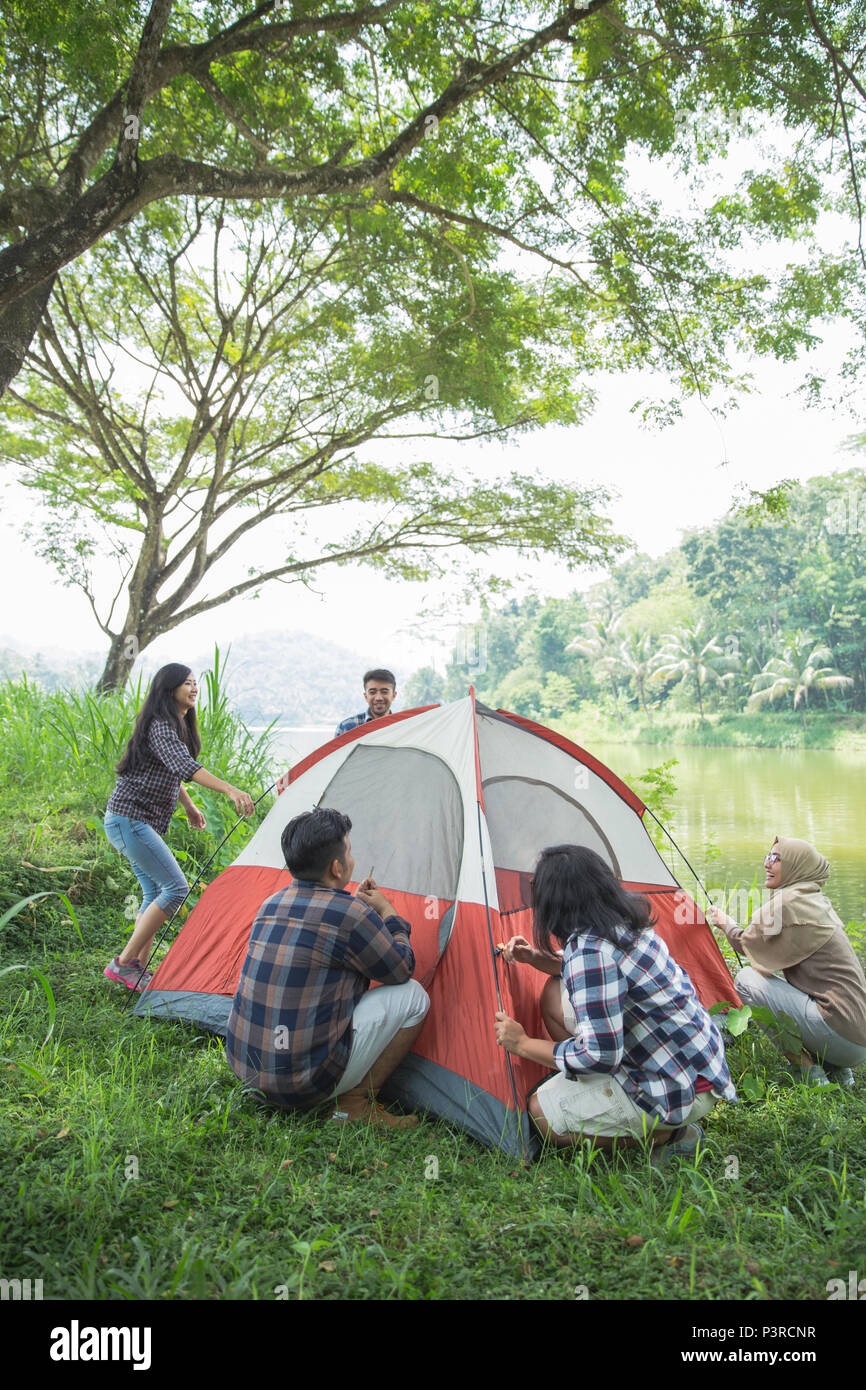 tourist help each other prepare tent Stock Photo - Alamy