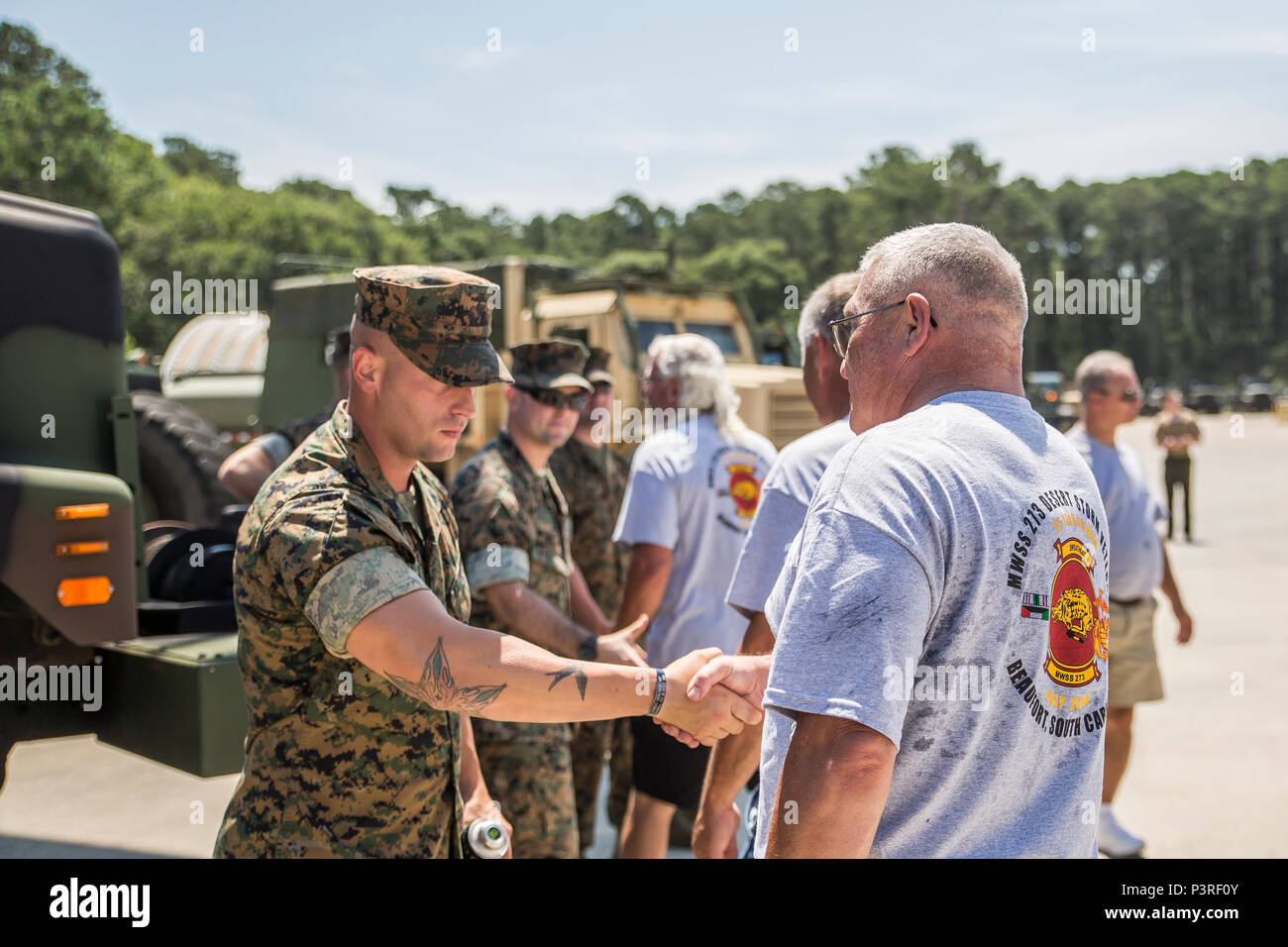Marines shake hands at the conclusion of their presentation aboard ...