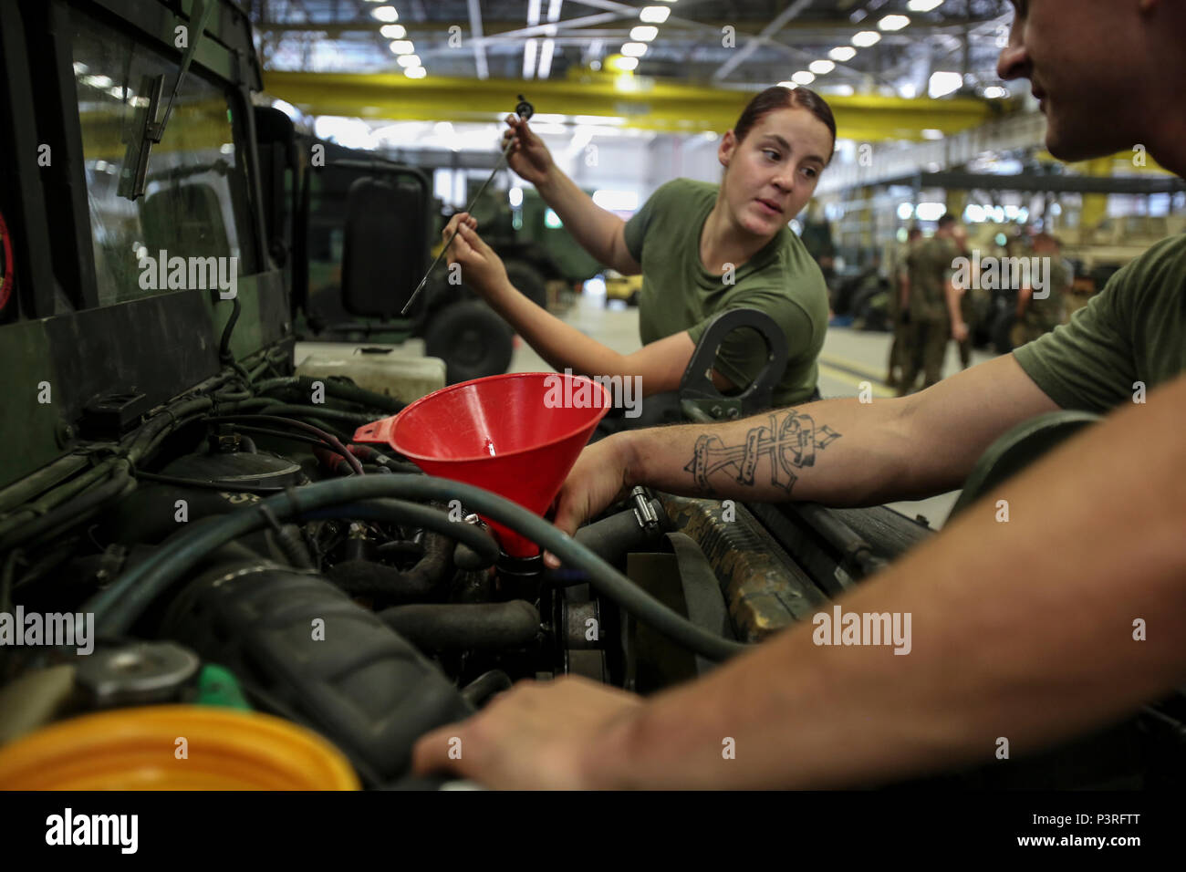 Two Marines with 2nd Maintenance Battalion work together to check the ...