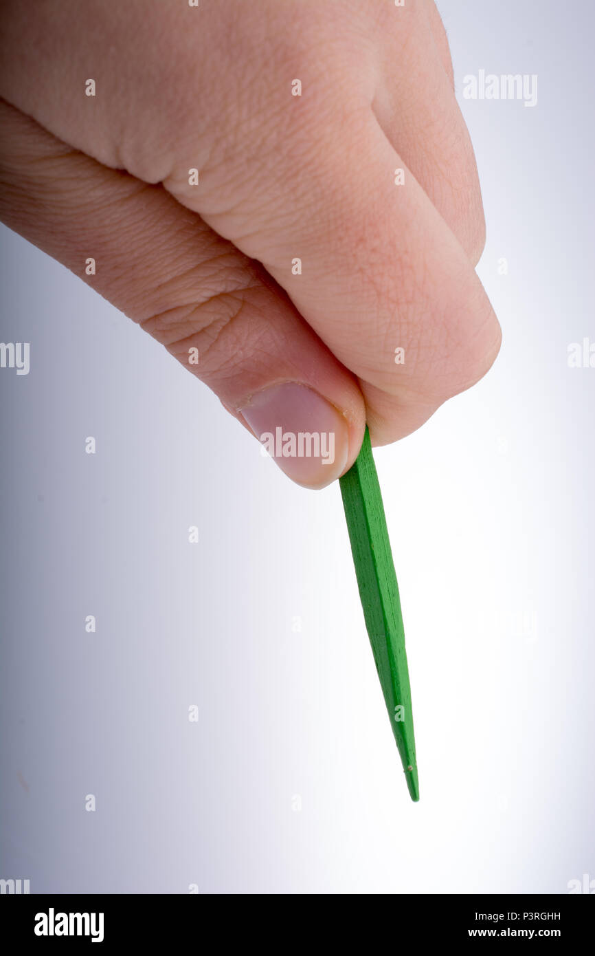 Little wooden sharp stick in hand on white background Stock Photo - Alamy