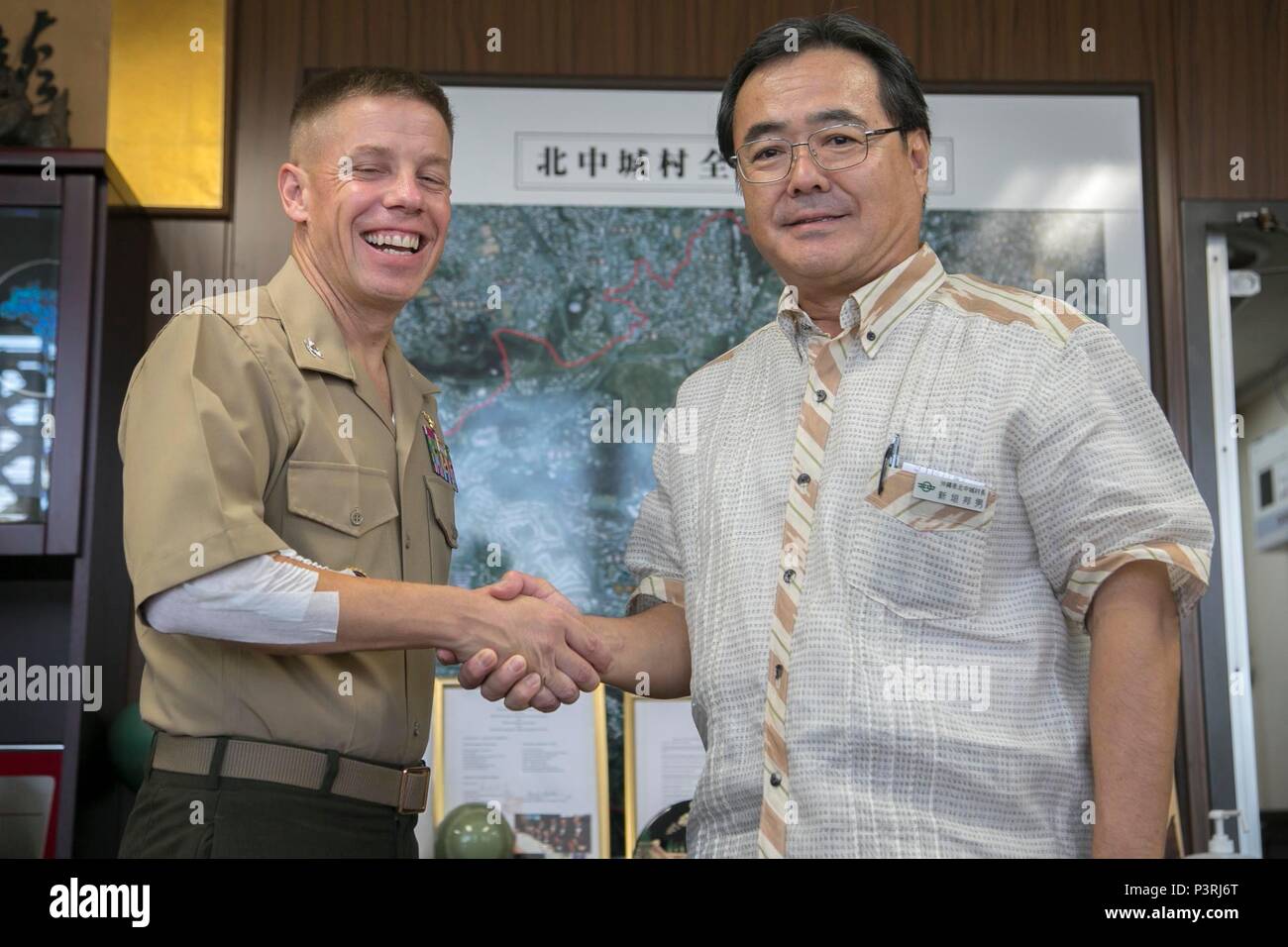 Col. William L. DePue, left, shakes hands with Kunio Arakaki July 28 in ...