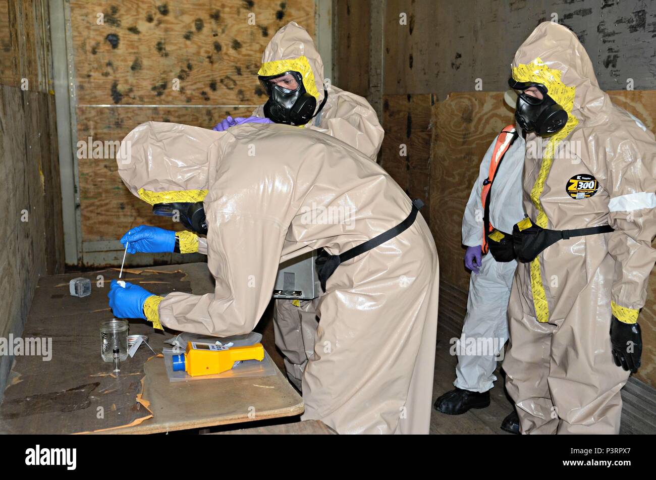 Members of the U.S. Army 11th Chemical Company (CBRNE) collect a sample ...