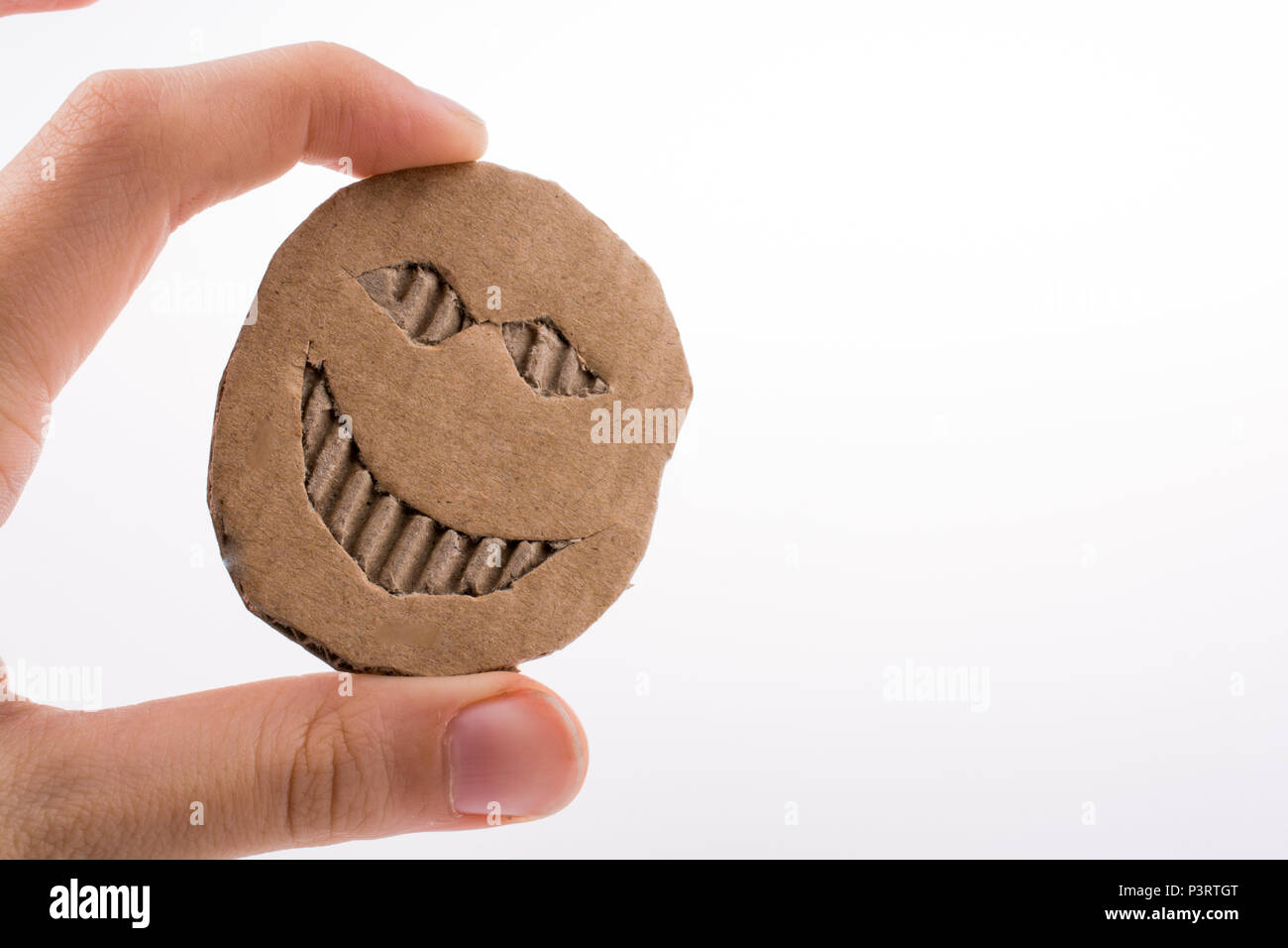 Hand holding a cardboard paper with smiley face Stock Photo - Alamy