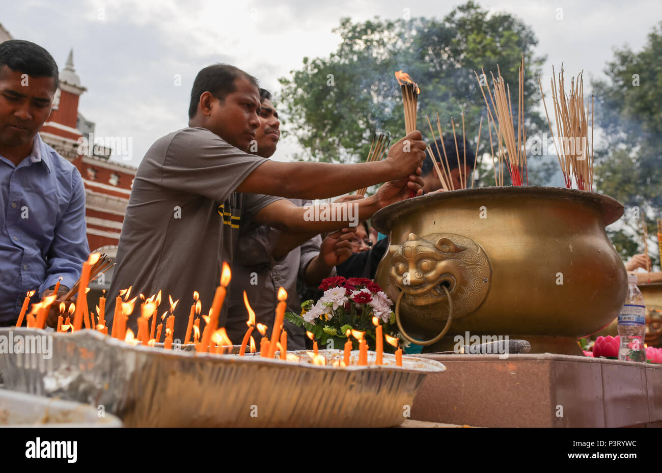 Buddhists praying with joss sticks and lotus candles at Maha Vihara ...