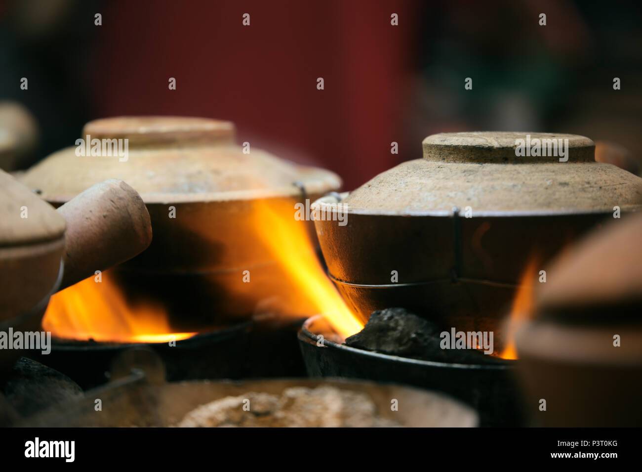 Meal preparation using clay pot on charcoal fire Stock Photo - Alamy