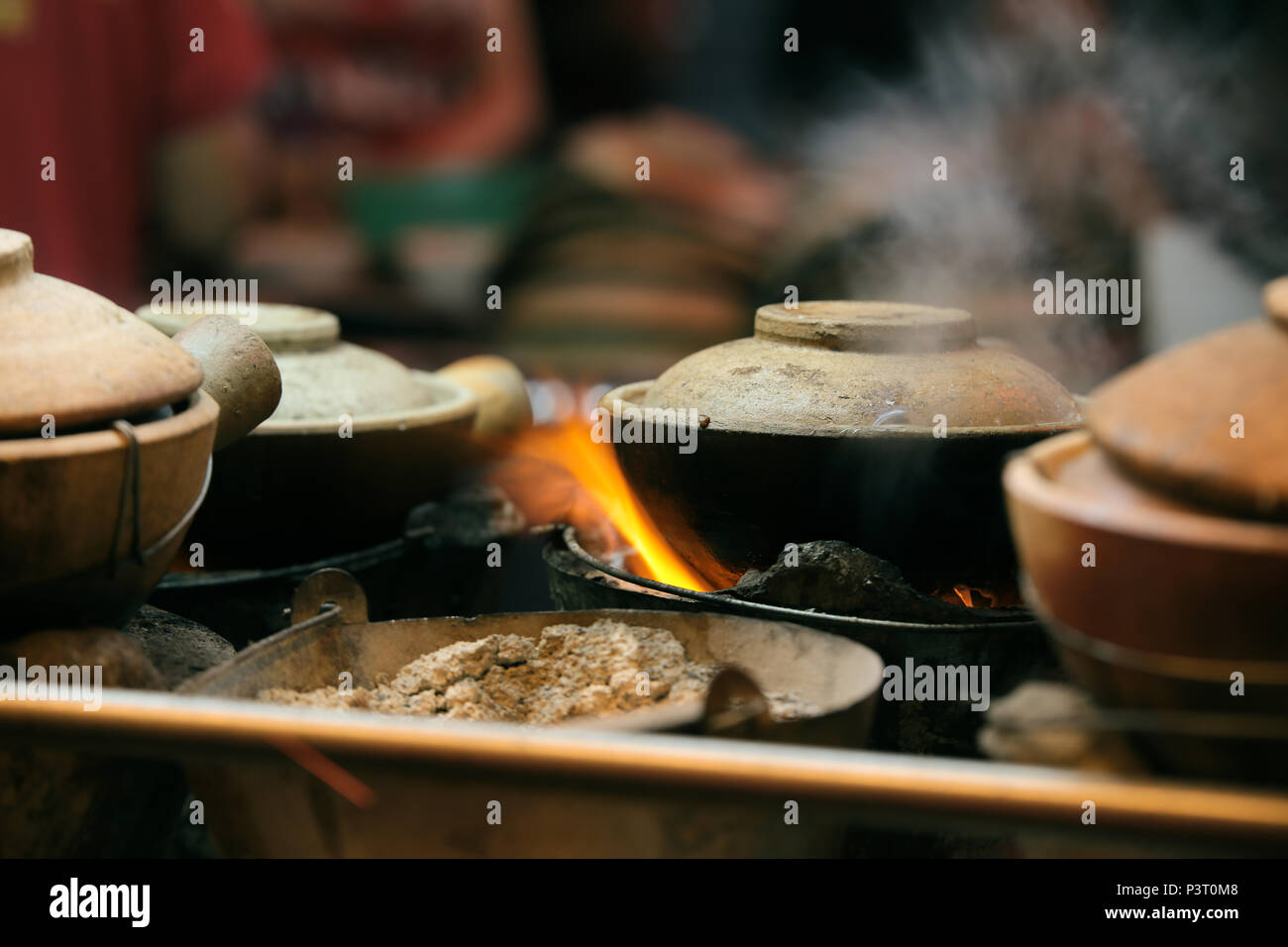 Meal preparation using clay pot on charcoal fire Stock Photo - Alamy