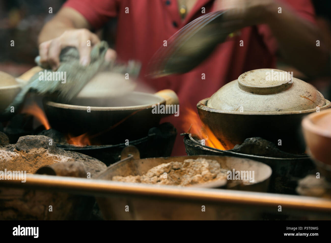 Meal preparation using clay pot on charcoal fire Stock Photo - Alamy