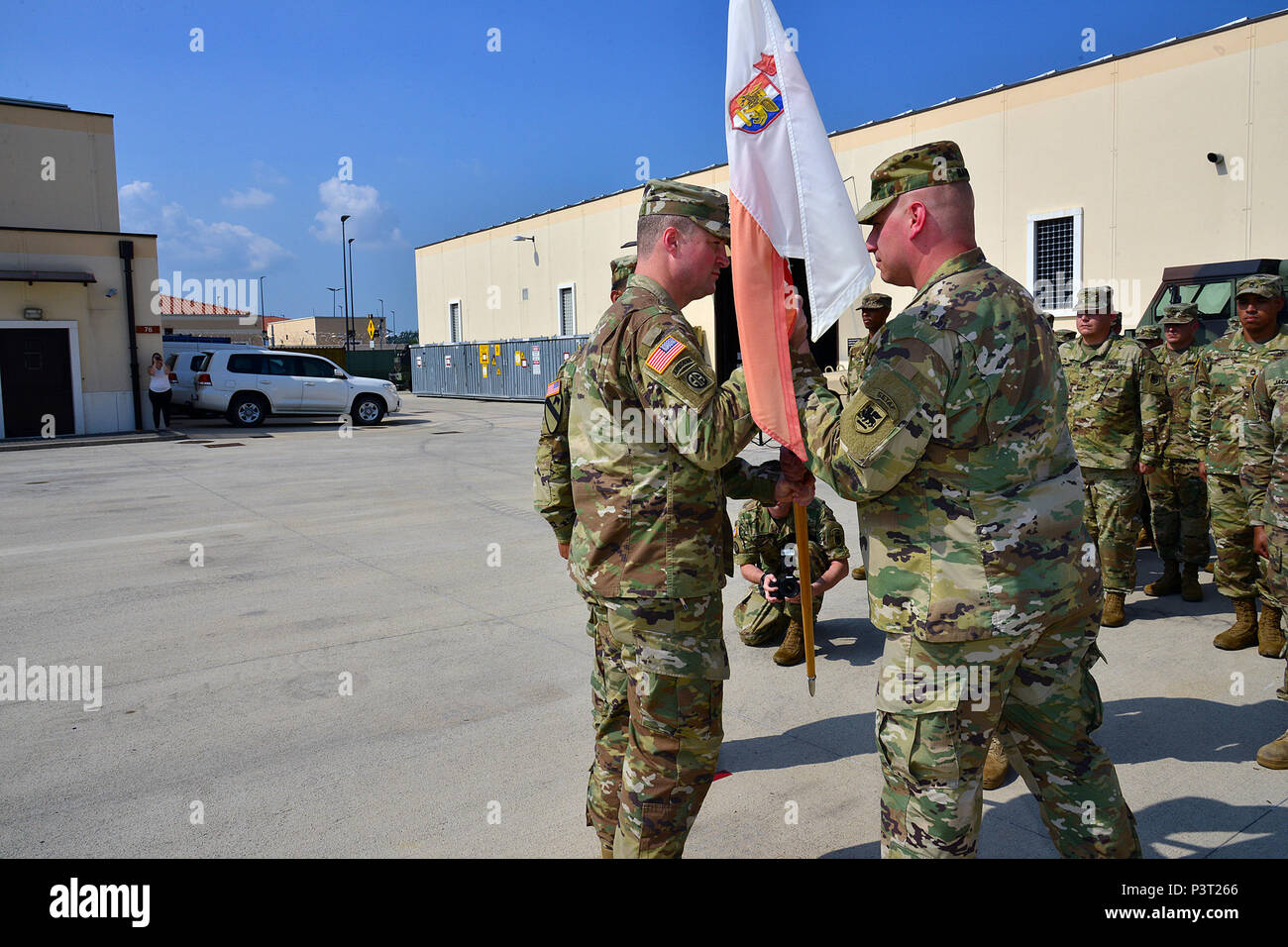 Capt. Nicholas F. Barber, right, passes the guidon to Lt. Col. Brett M. Medlin, left, commander ...