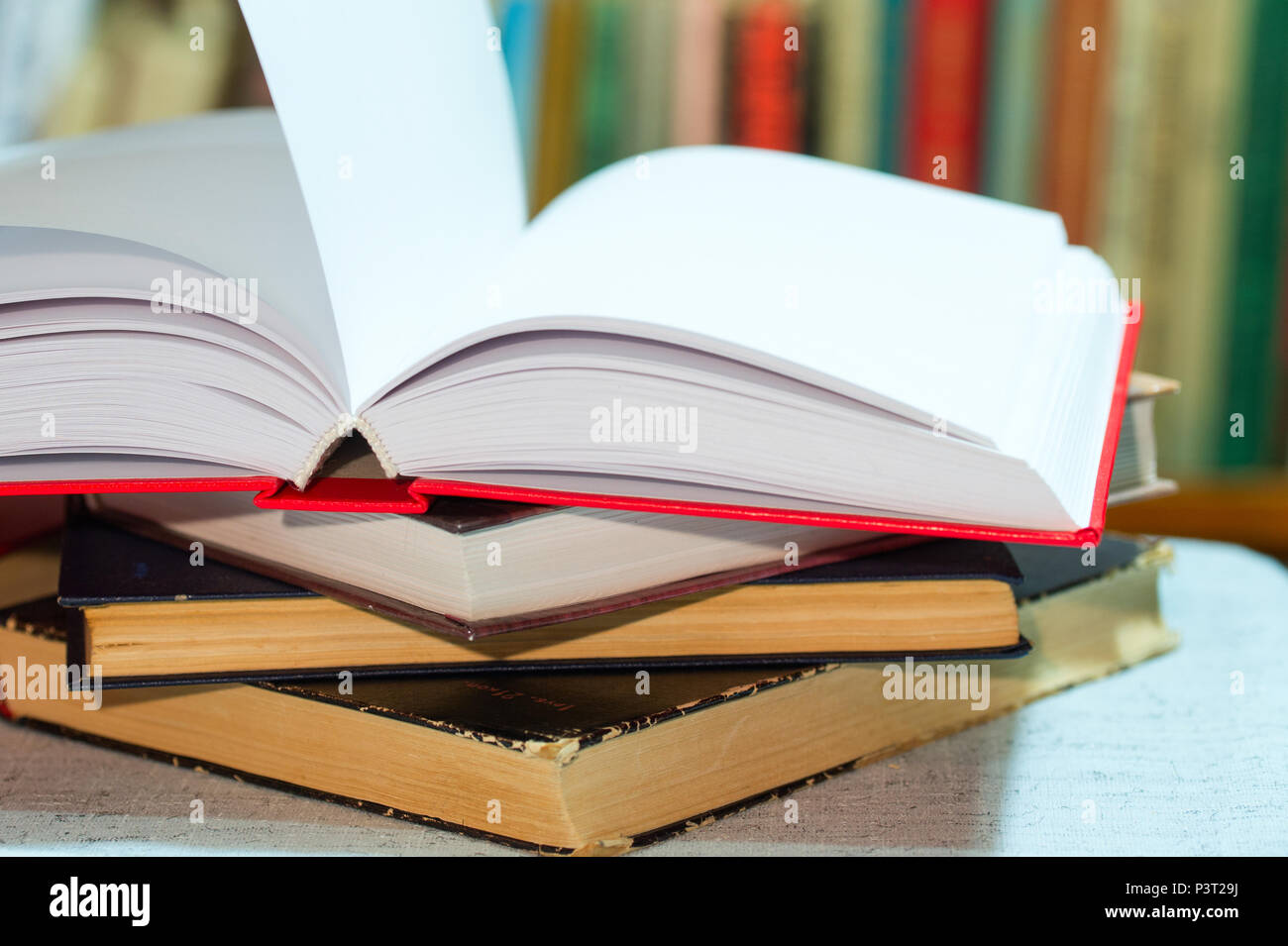Open book, stack of hardback books on table. Top view Stock Photo - Alamy