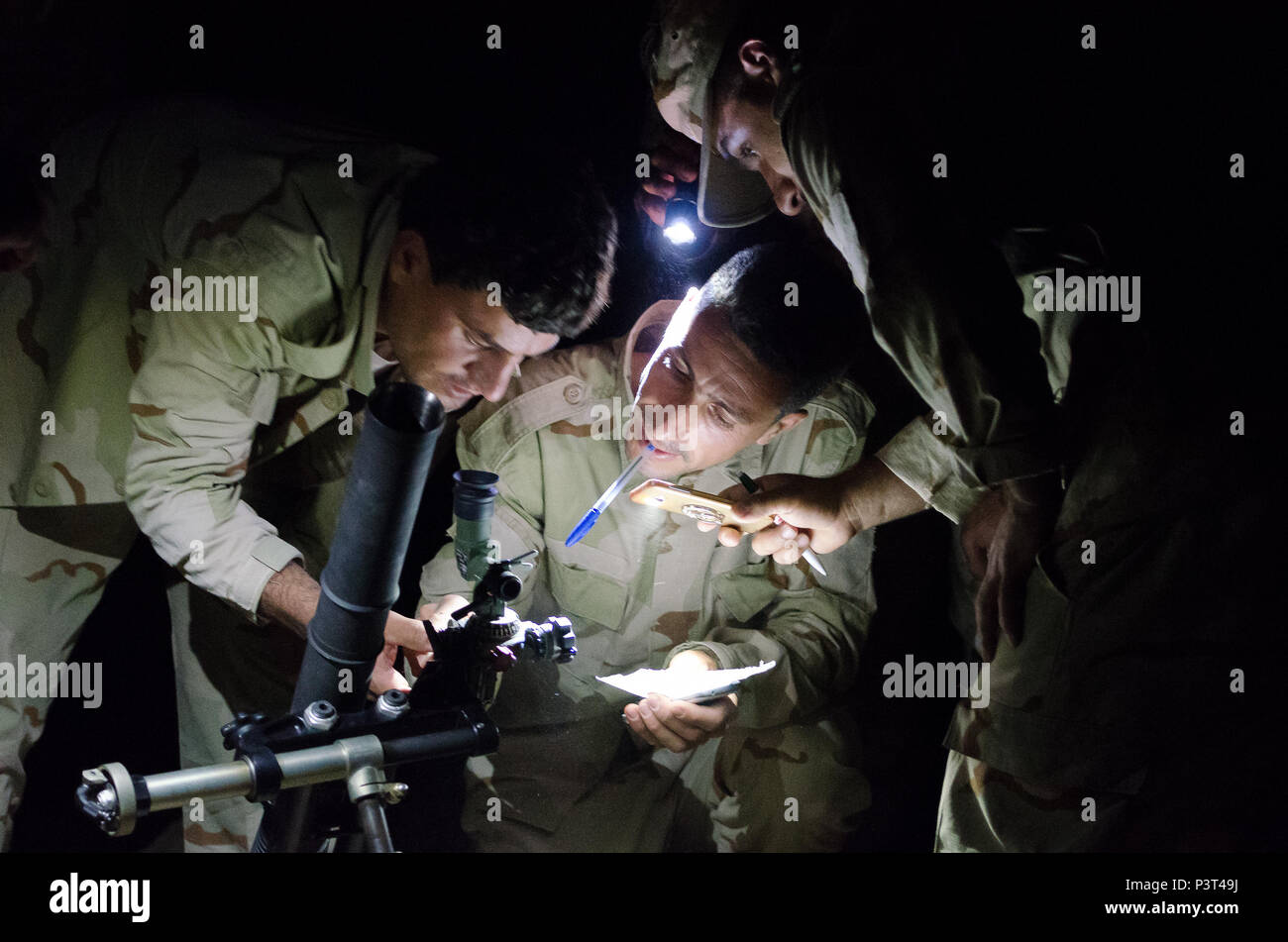 Peshmerga soldiers adjust the settings of an M224 60mm mortar system to ...