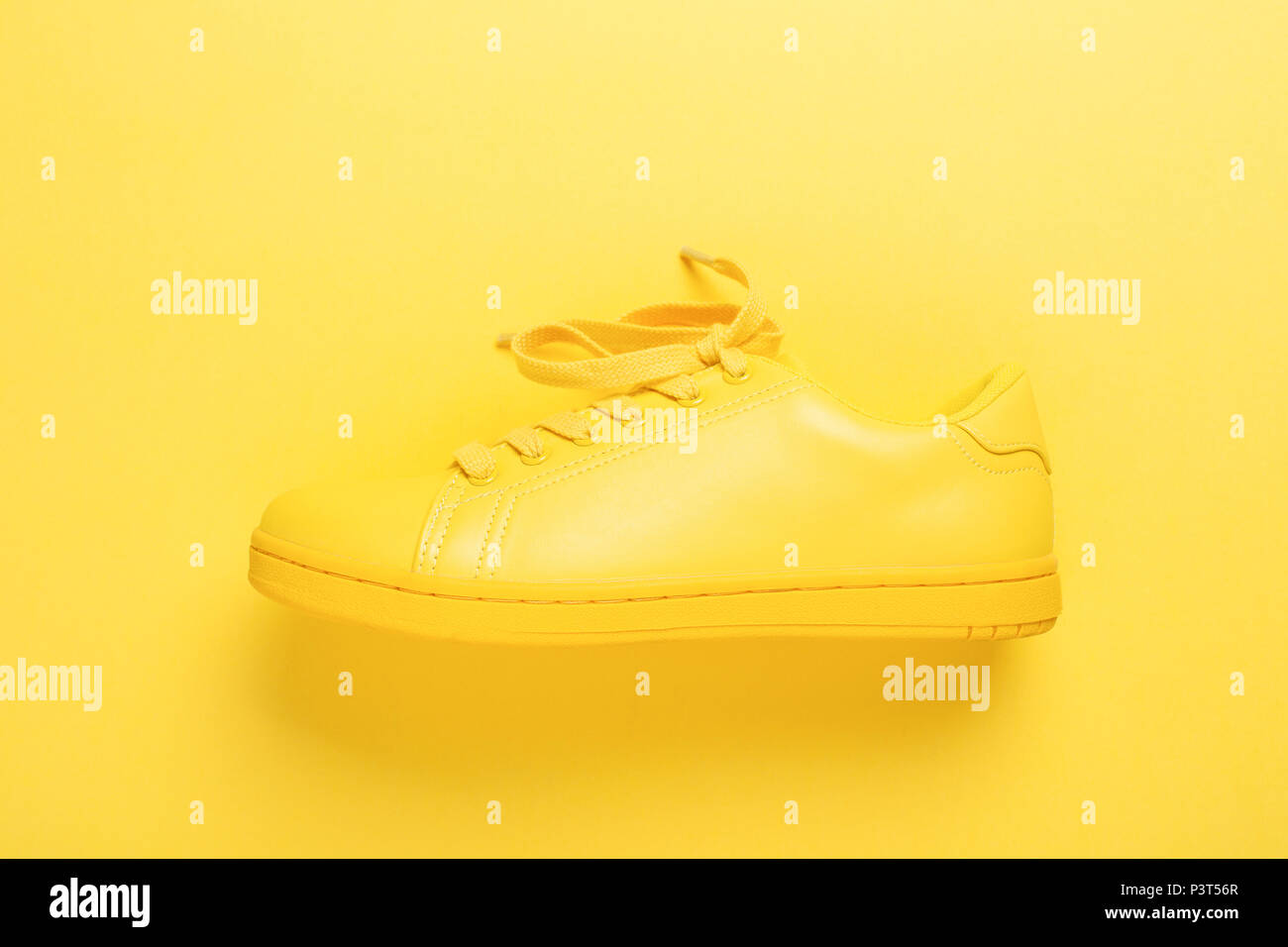 One yellow shoe on yellow background. Trendy summer color, monochrome ...