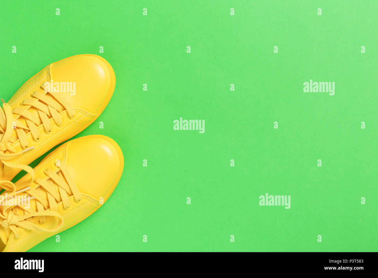 Pair of yellow shoes on green background. Trendy summer color Stock ...