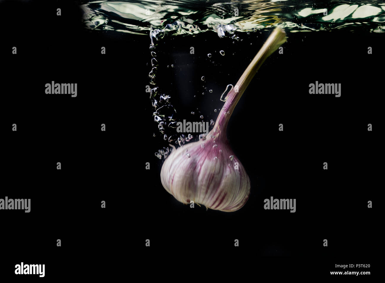 Garlic falls into the water. Splash of water Stock Photo - Alamy