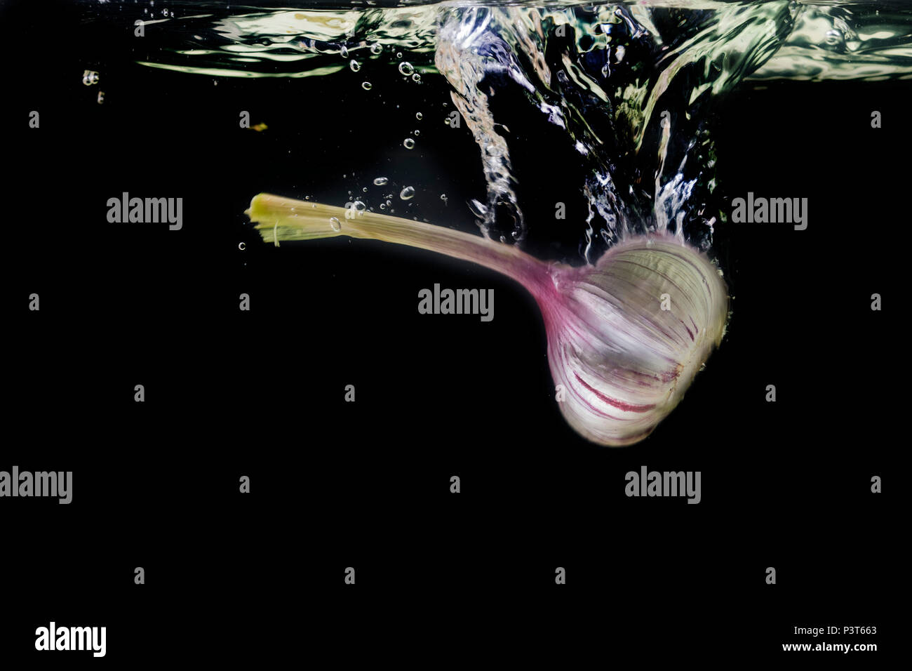 Garlic falls into the water. Splash of water Stock Photo - Alamy