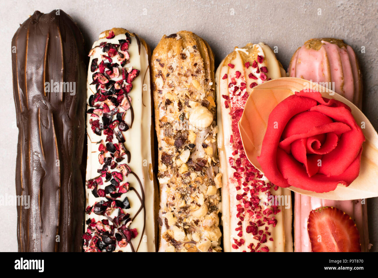 Sweet delicious colorful french eclairs decorated with marzipan red ...