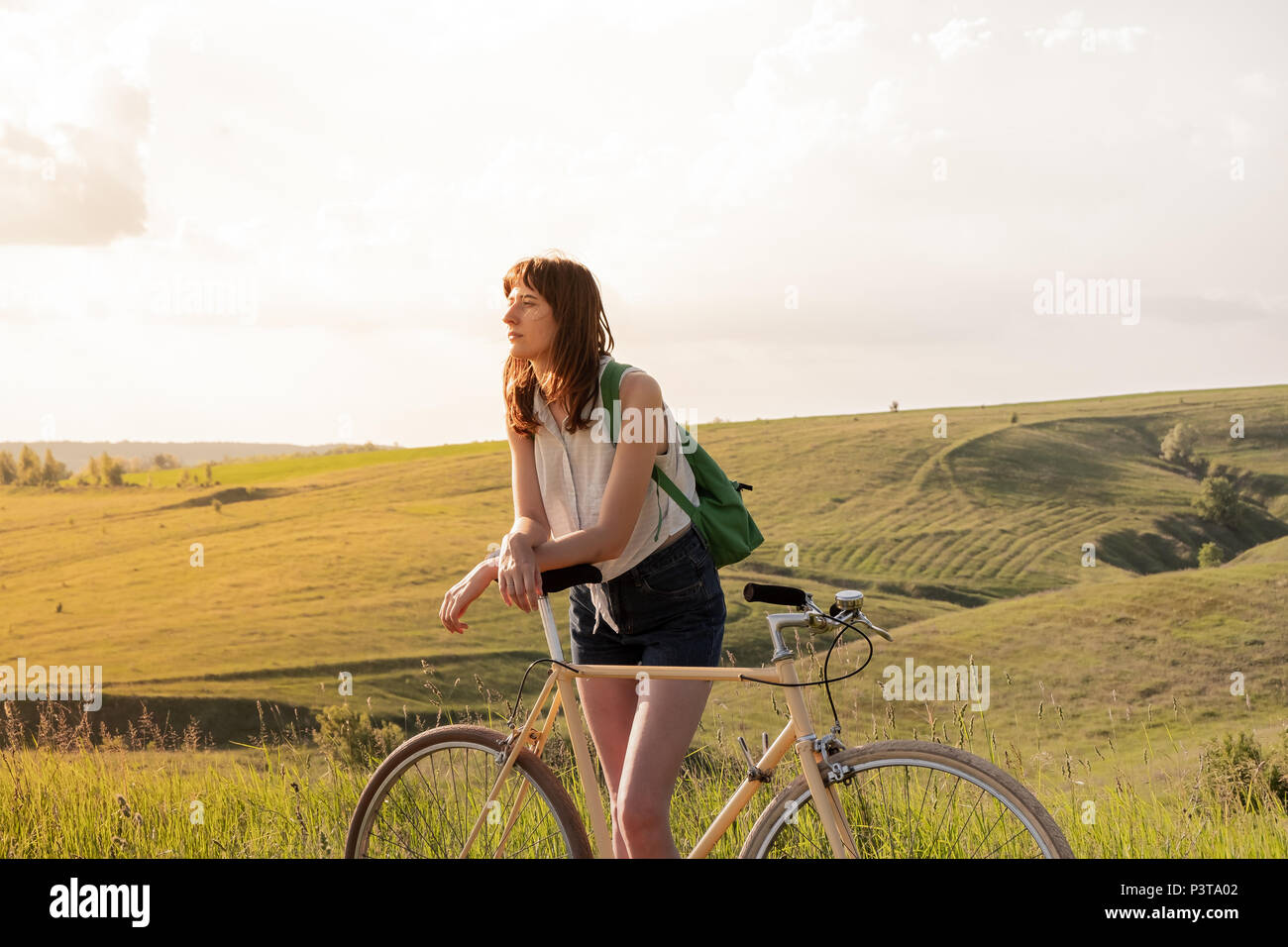 Girl with bicycle taking a rest in beautiful rural landscape. Young ...