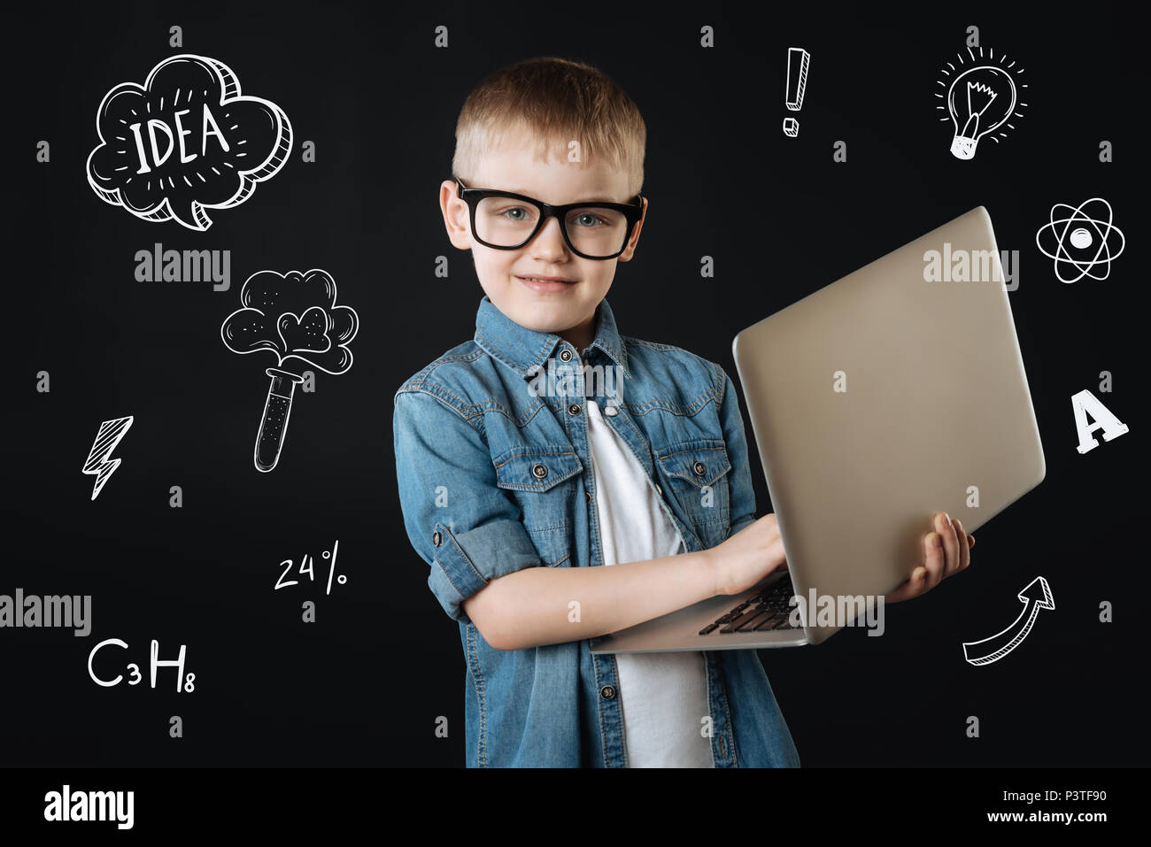 Progressive child feeling confident while holding a modern laptop Stock ...