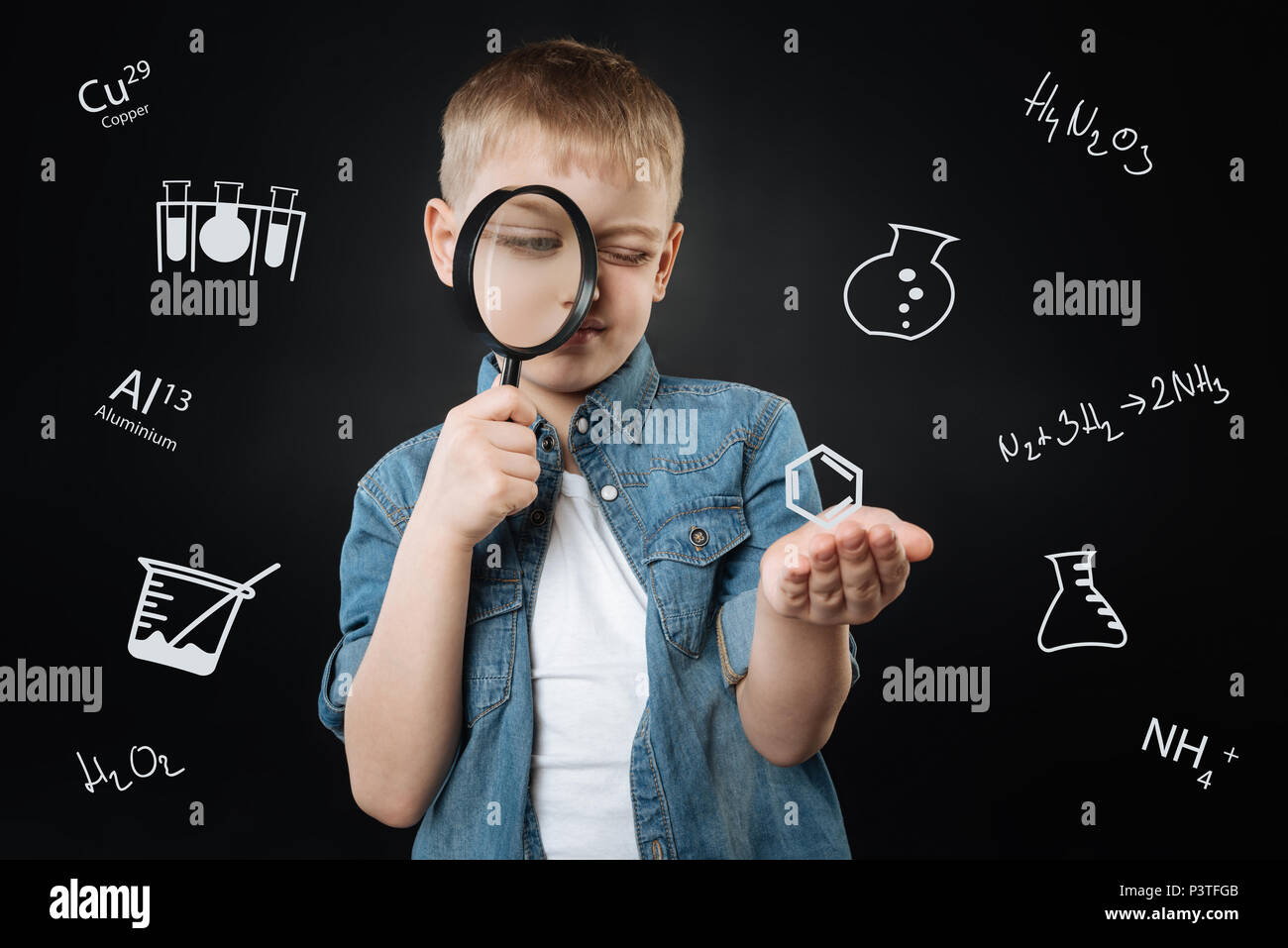 Curious boy holding a magnifying glass and looking through it Stock ...