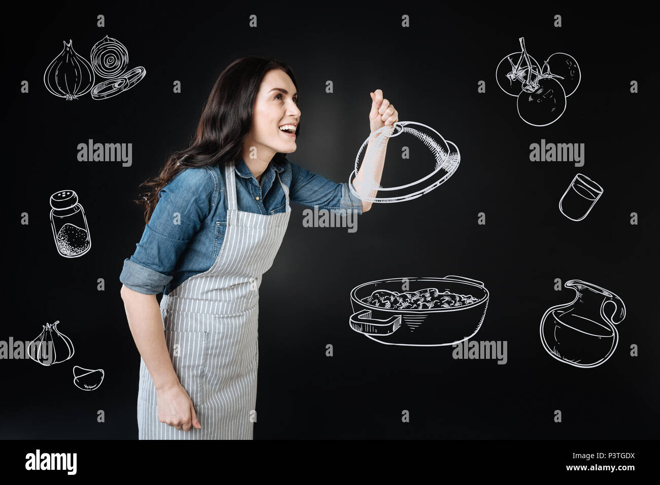 Emotional housewife smiling while cooking supper Stock Photo - Alamy